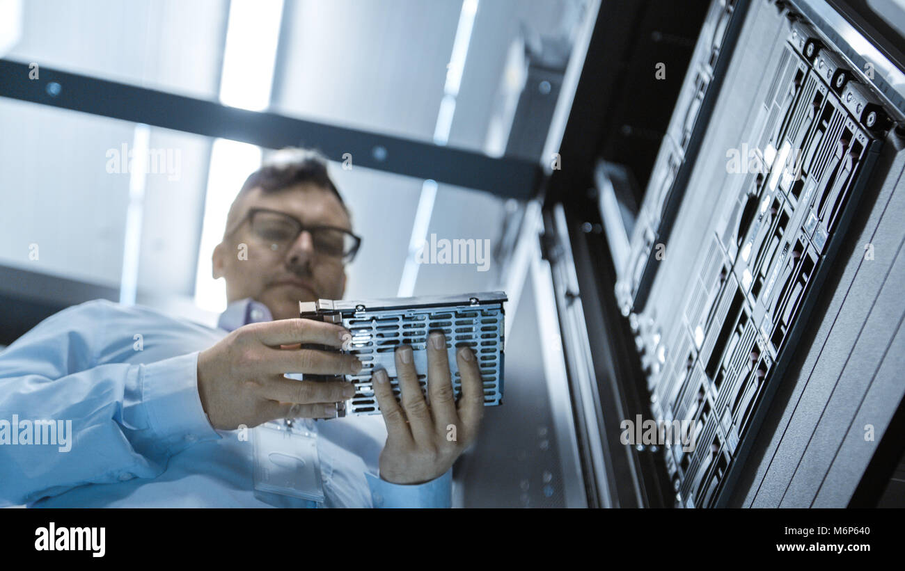 Low Angle Shot In Fully Working Data Center IT Engineer Installs Hard ...