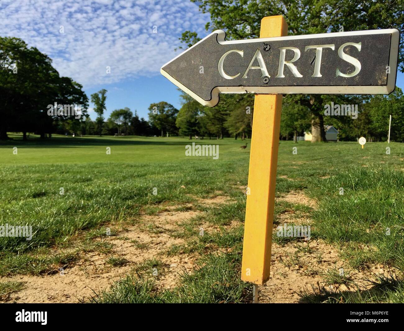 Golf course cart arrow directional sign towards paved path for player ...