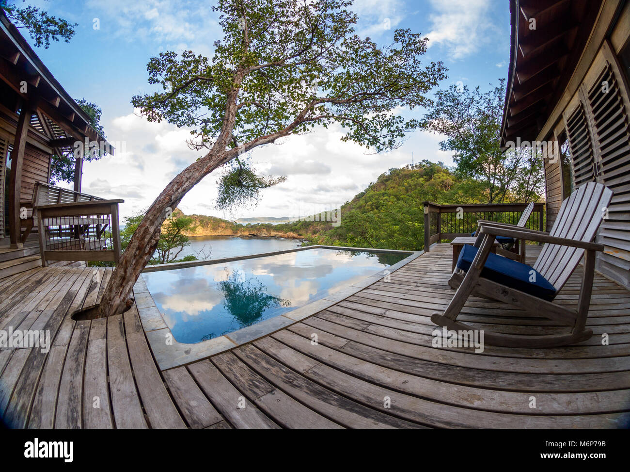 relaxing scene with a calm pool and a wooden deck and building with the ...