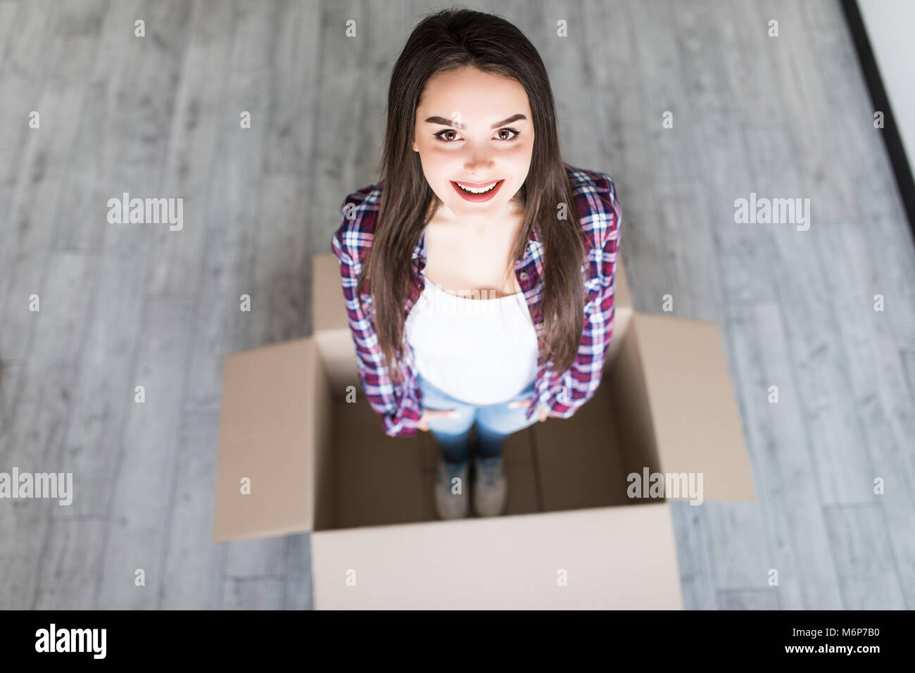 Woman sitting inside a cardboard box while packing Stock Photo - Alamy