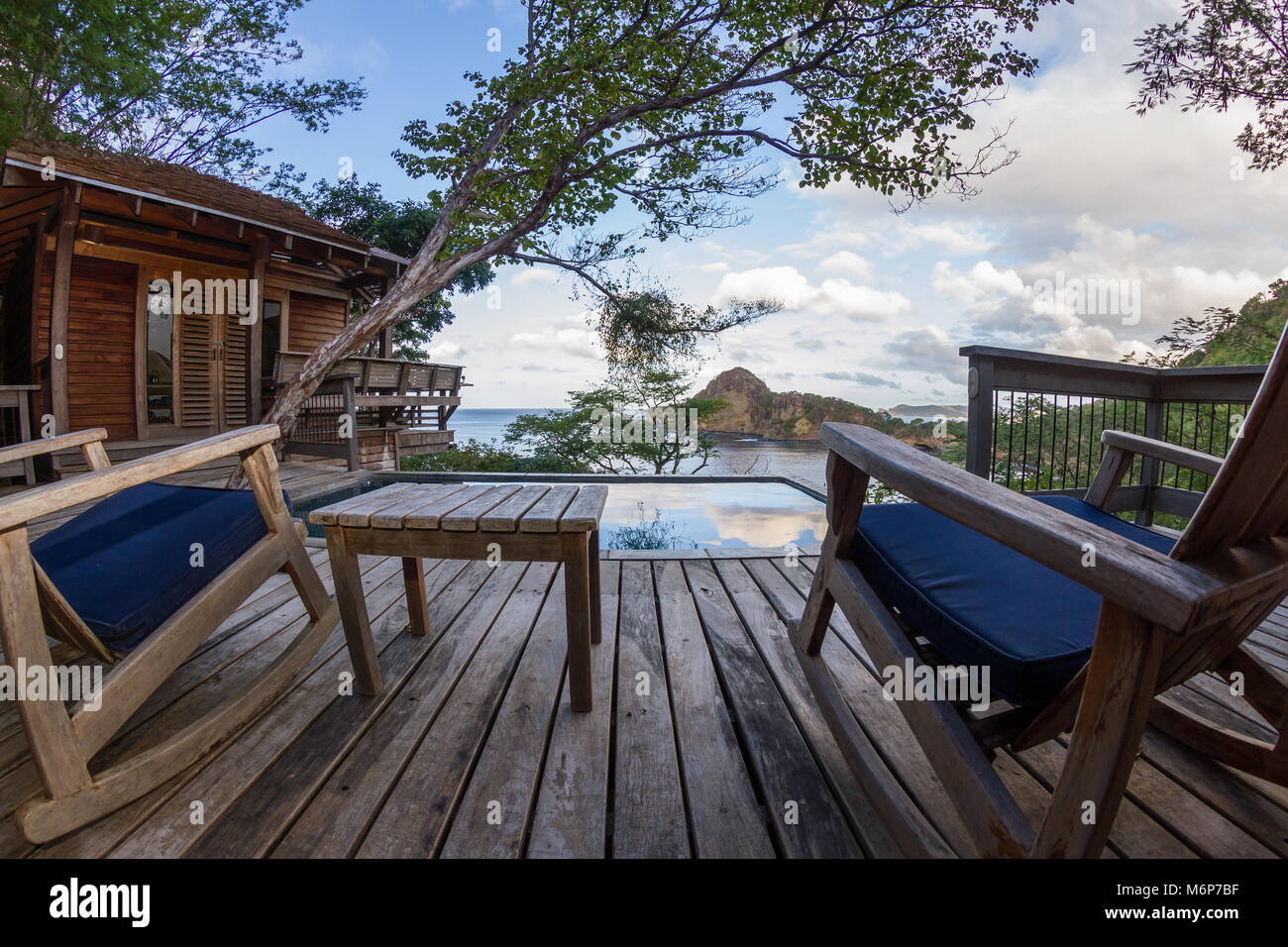 relaxing scene with a calm pool and a wooden deck and building with the ...