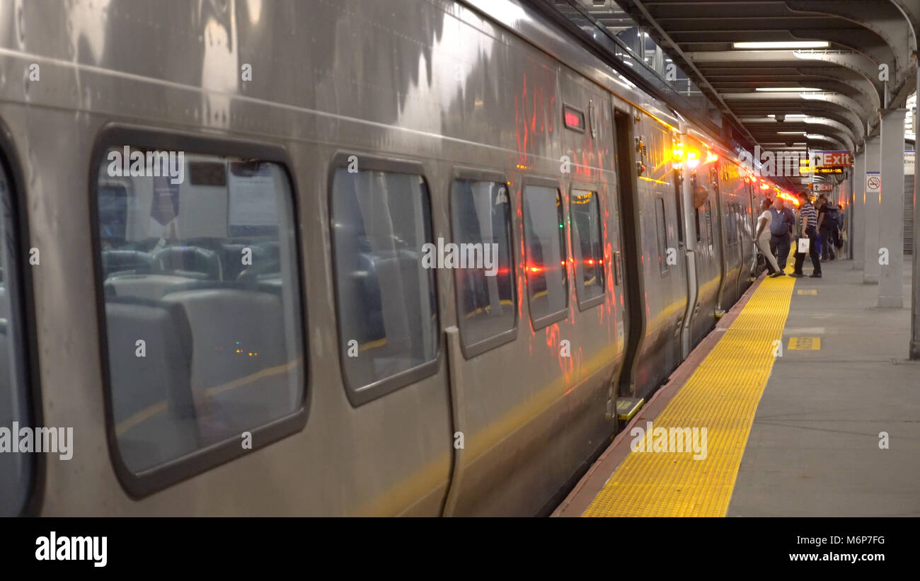 Train passengers board rush hour train at terminal railroad station to ...