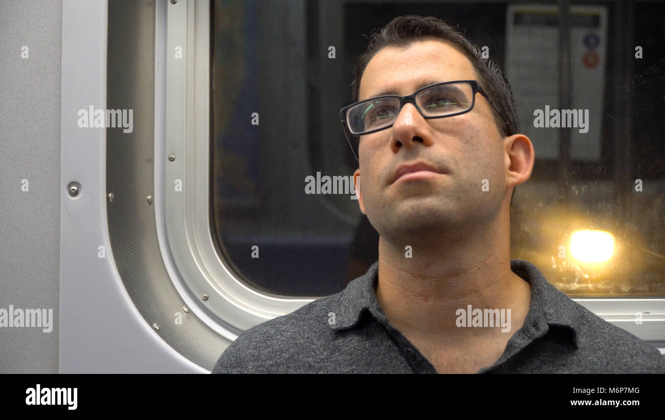 Young attractive man rides NYC subway train travel to work during rush ...
