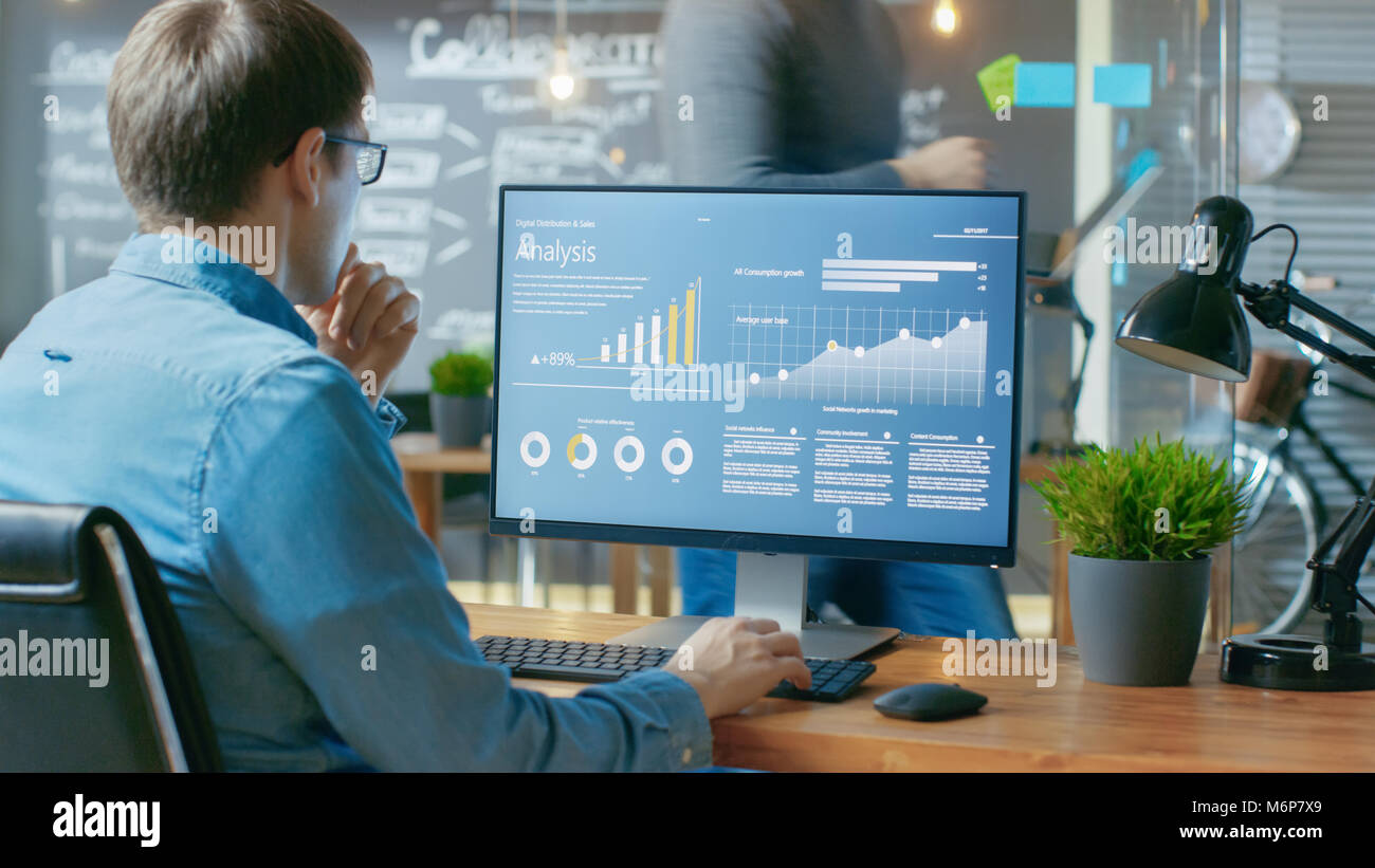 Analyst Works on a Personal Computer Showing Statistics, Graphs and ...