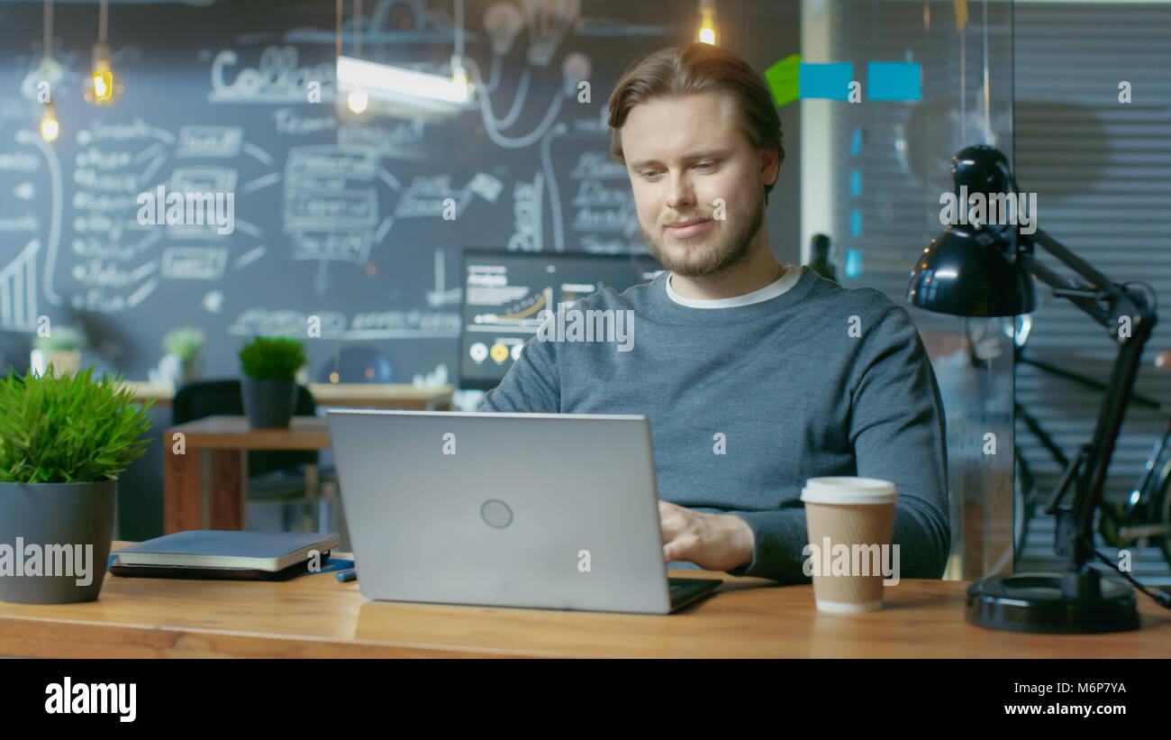 Handsome Young Office Employee Typing on a Laptop Computer, He ...