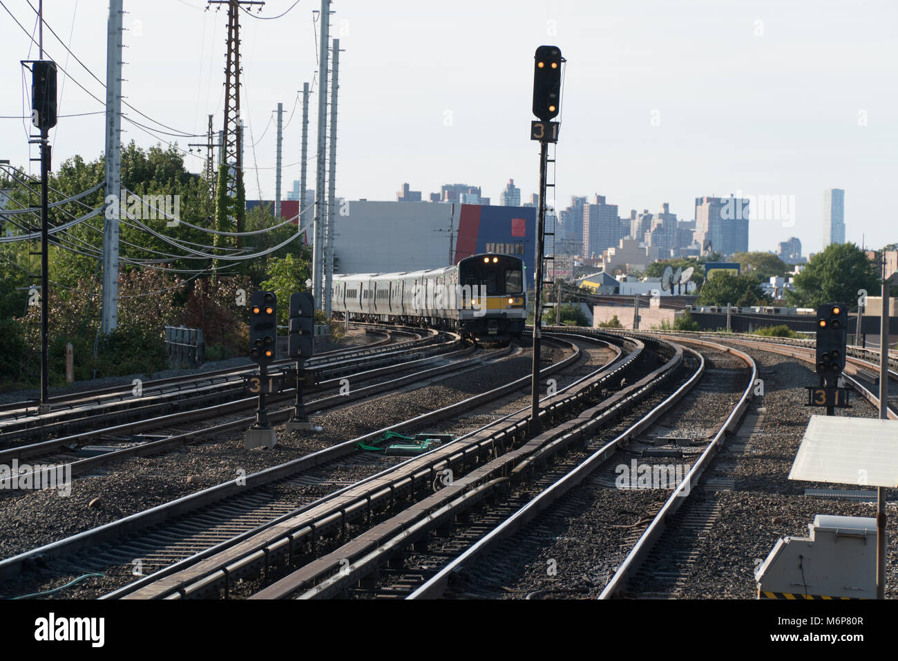 Generic commuter train traveling on track with New York City skyline in ...
