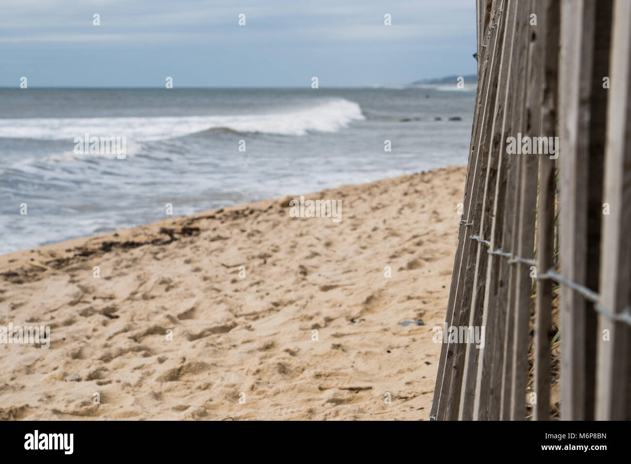 Wide view of an ocean front beach along the coast line past a wood ...