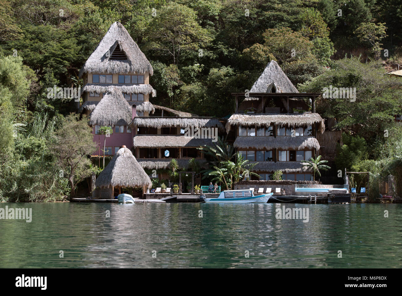 A modern hotel built in traditional Mayan style with thatched roof ...