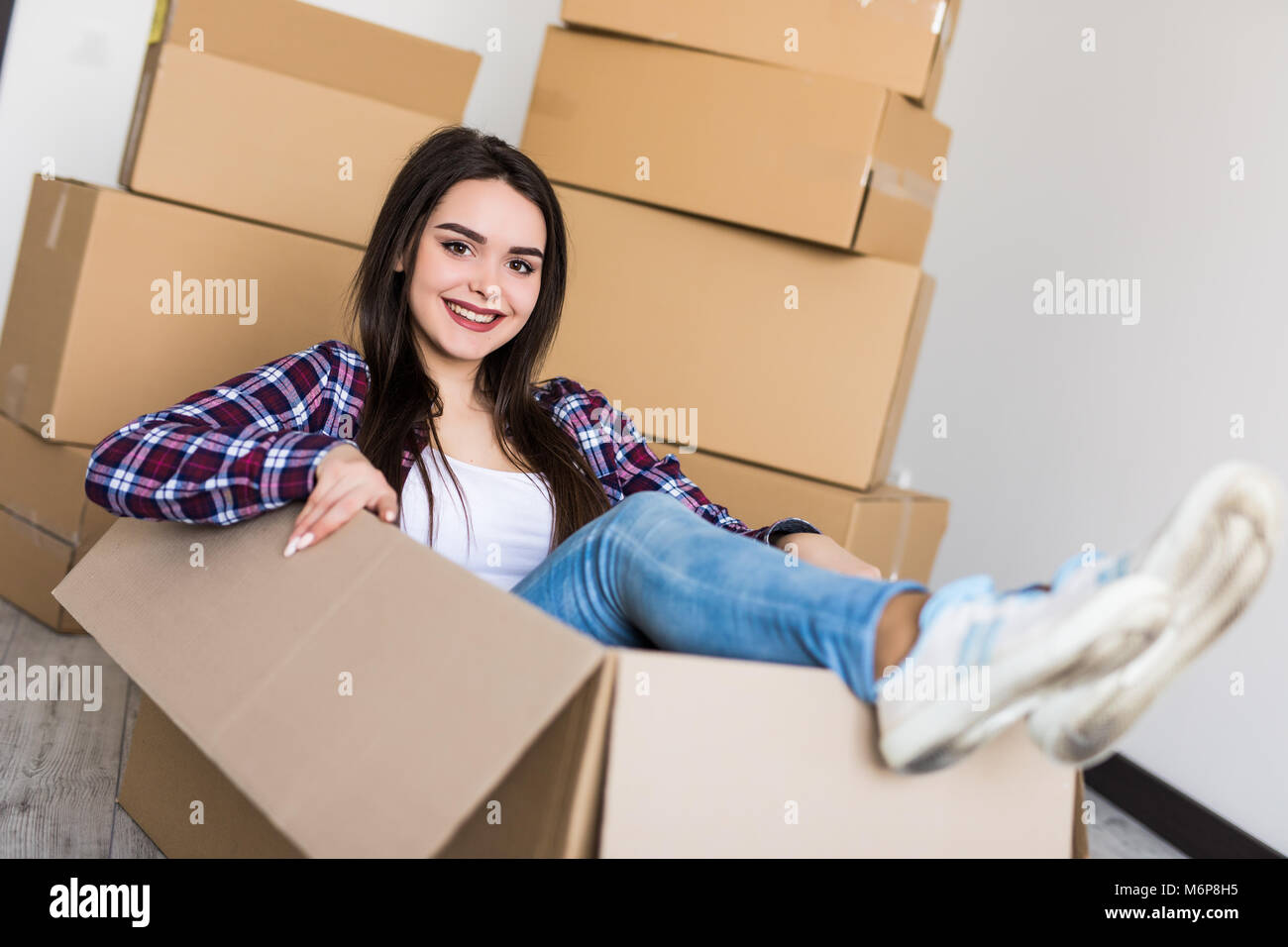 Woman sitting inside a cardboard box while packing Stock Photo - Alamy