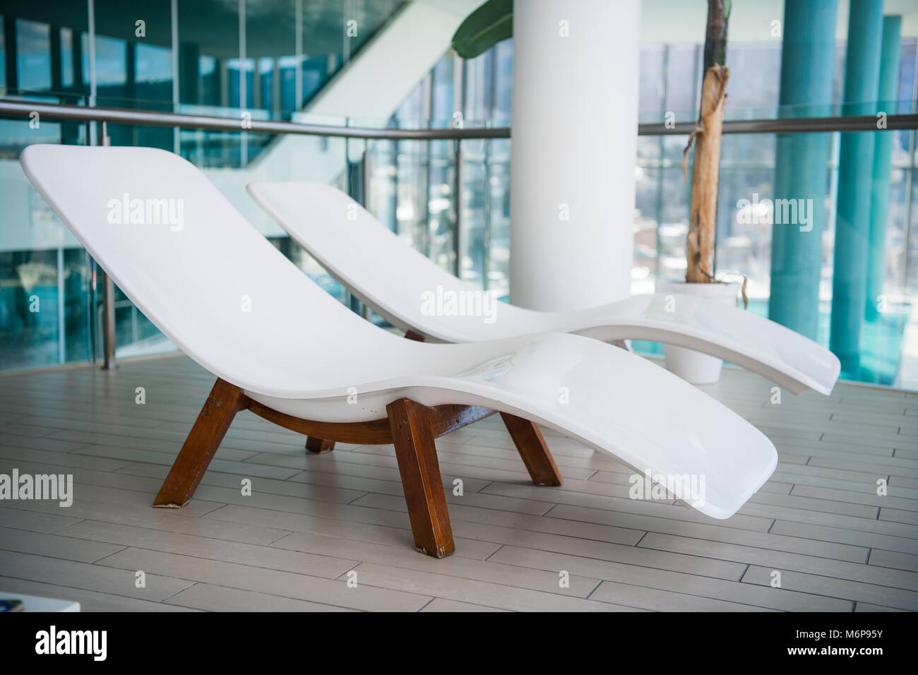 Modern deck chairs at luxury hotel. Private swimming pool for ...