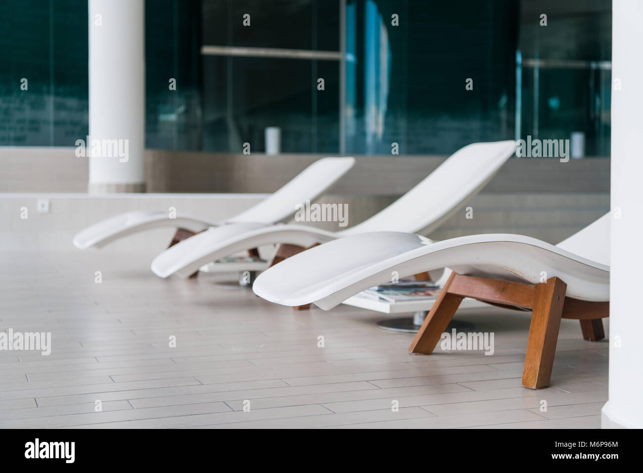 Modern deck chairs at luxury hotel. Private swimming pool for ...