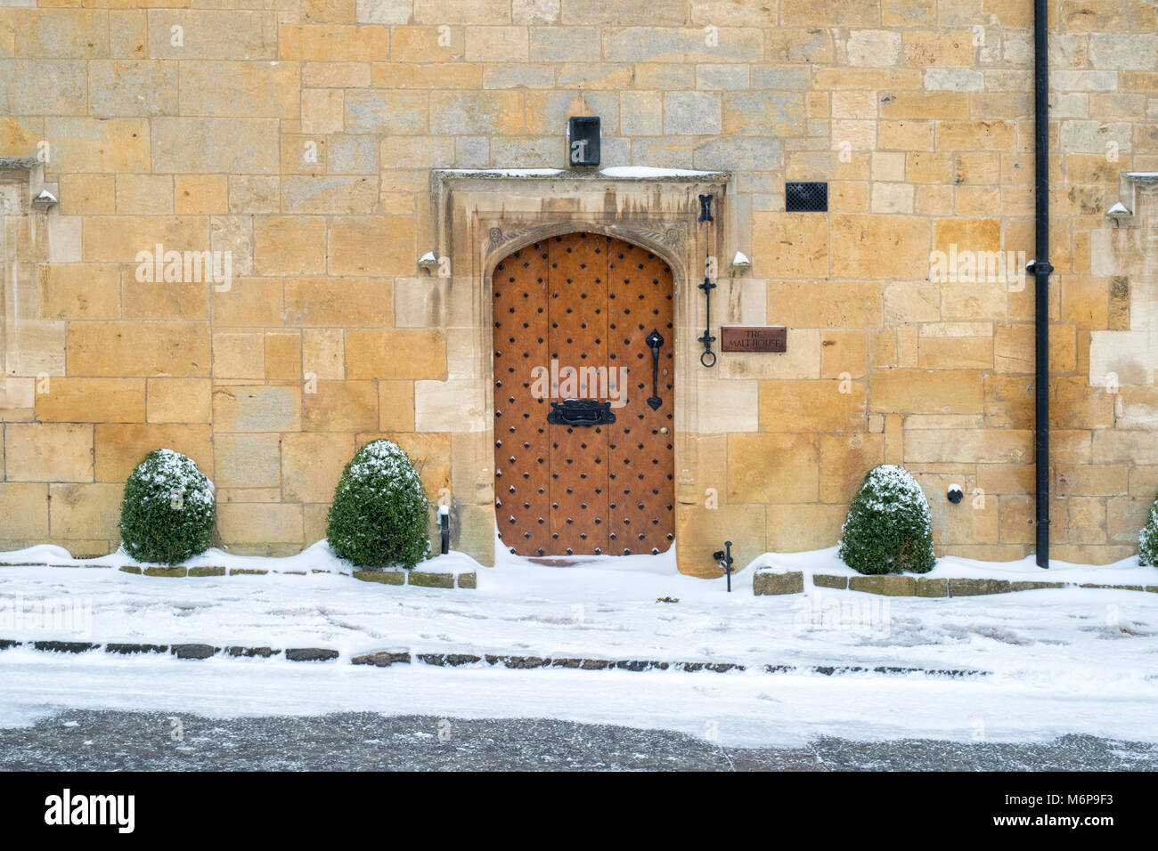 Broadway stone cottage wooden door in the winter snow. Broadway ...