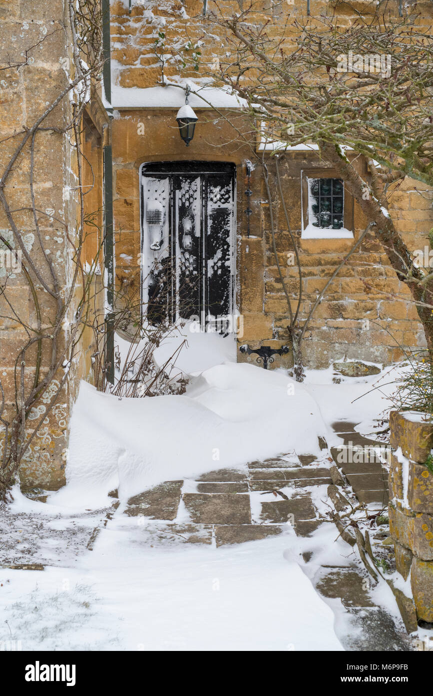Broadway stone cottage wooden door in the winter snow. Broadway ...
