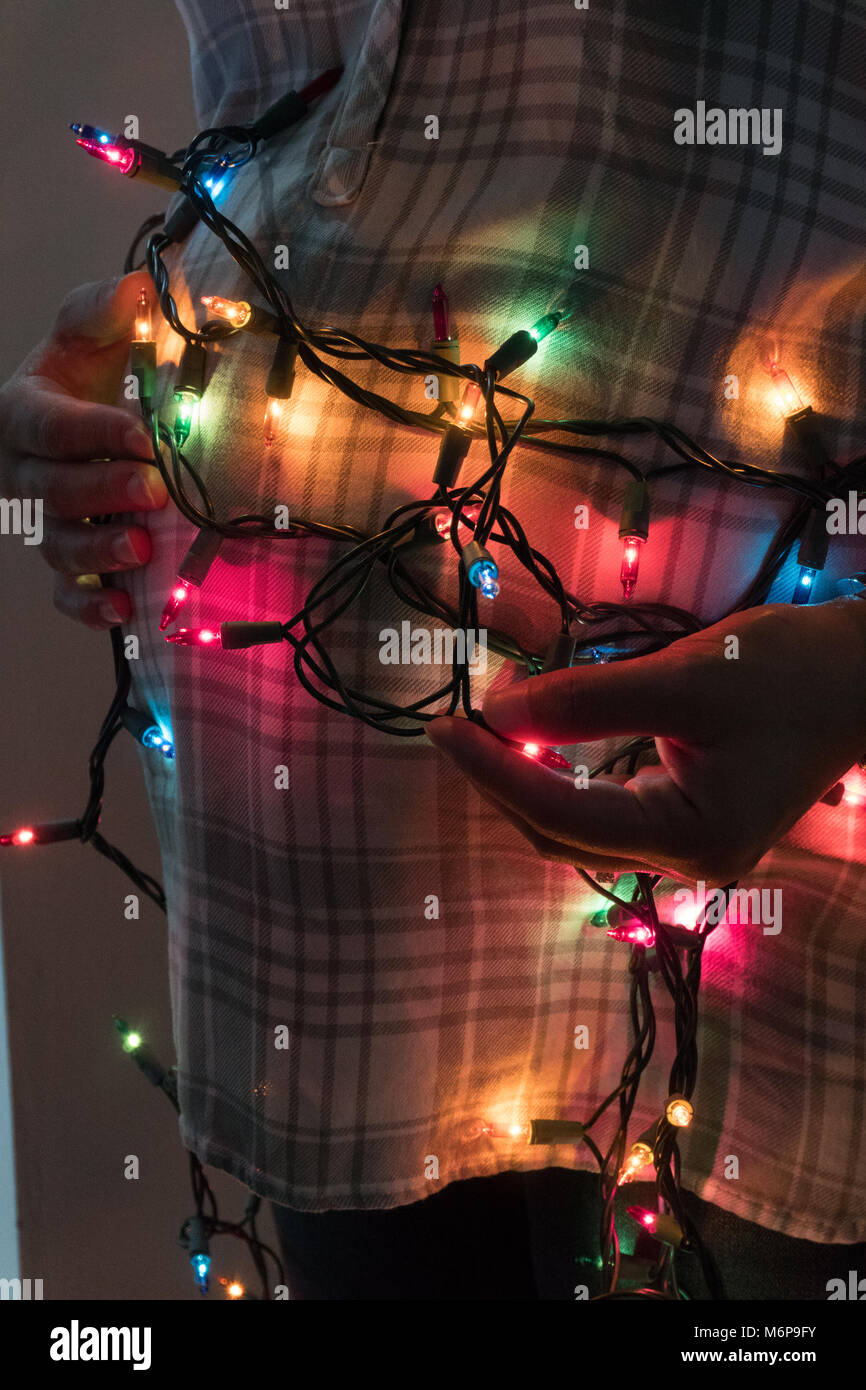Christmas lights held in front of pregnant mommy belly to symbolize a ...