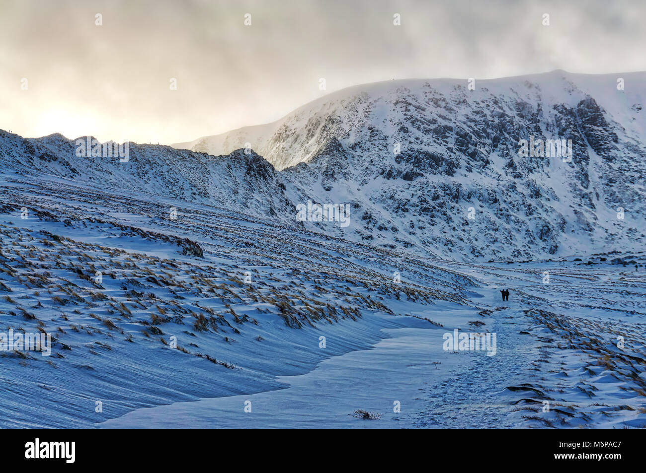 A view of a snow covered Helvellyn from the path to Red Tarn Stock ...