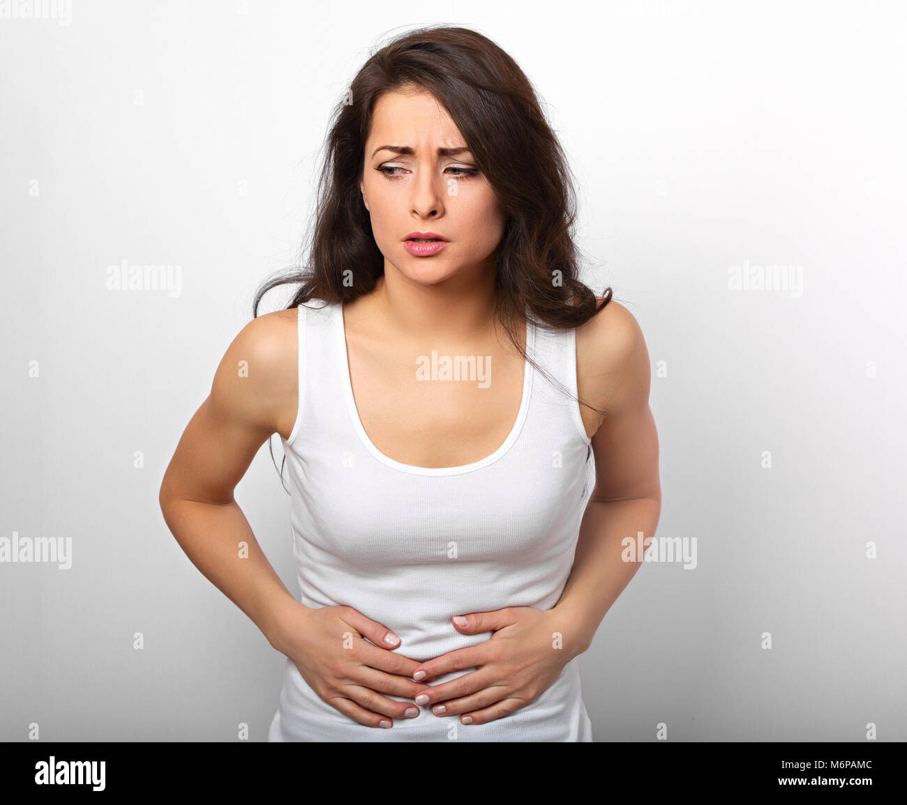 Beautiful stressed casual sad woman suffering from pain in stomach on ...