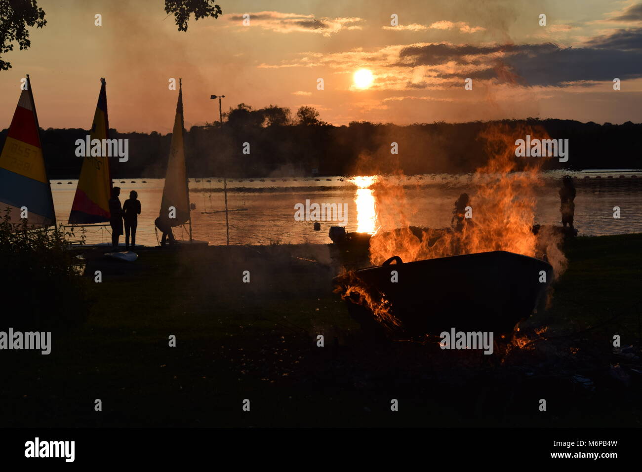 Bonfire with burning sailing dinghy as the sun goes down, sunset ...