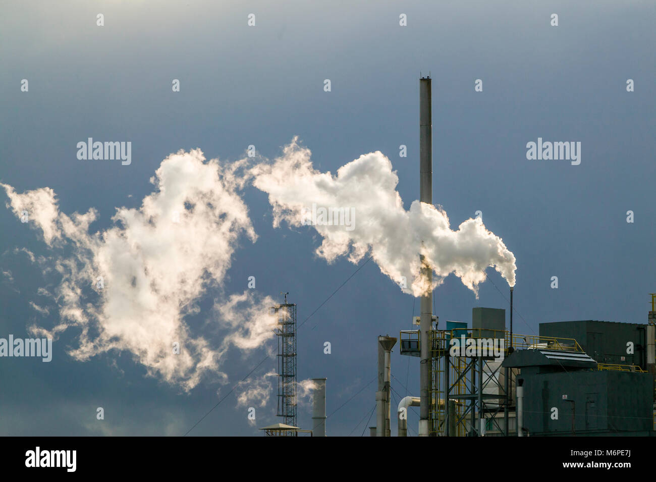 Industrial smoke stacks against ominous skies Stock Photo - Alamy