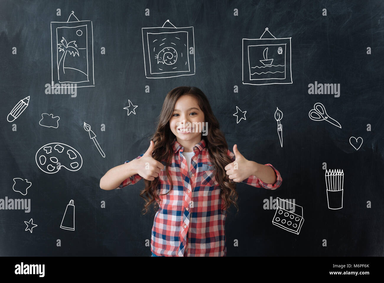 Lovely child feeling happy while showing her drawings Stock Photo - Alamy