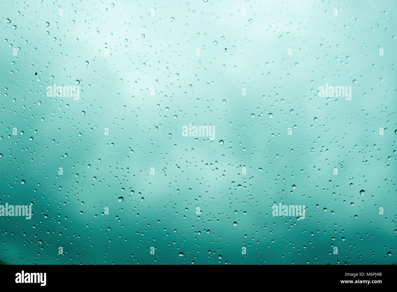 Rain drops on glass selective focus. Cloudy sky background Stock Photo ...