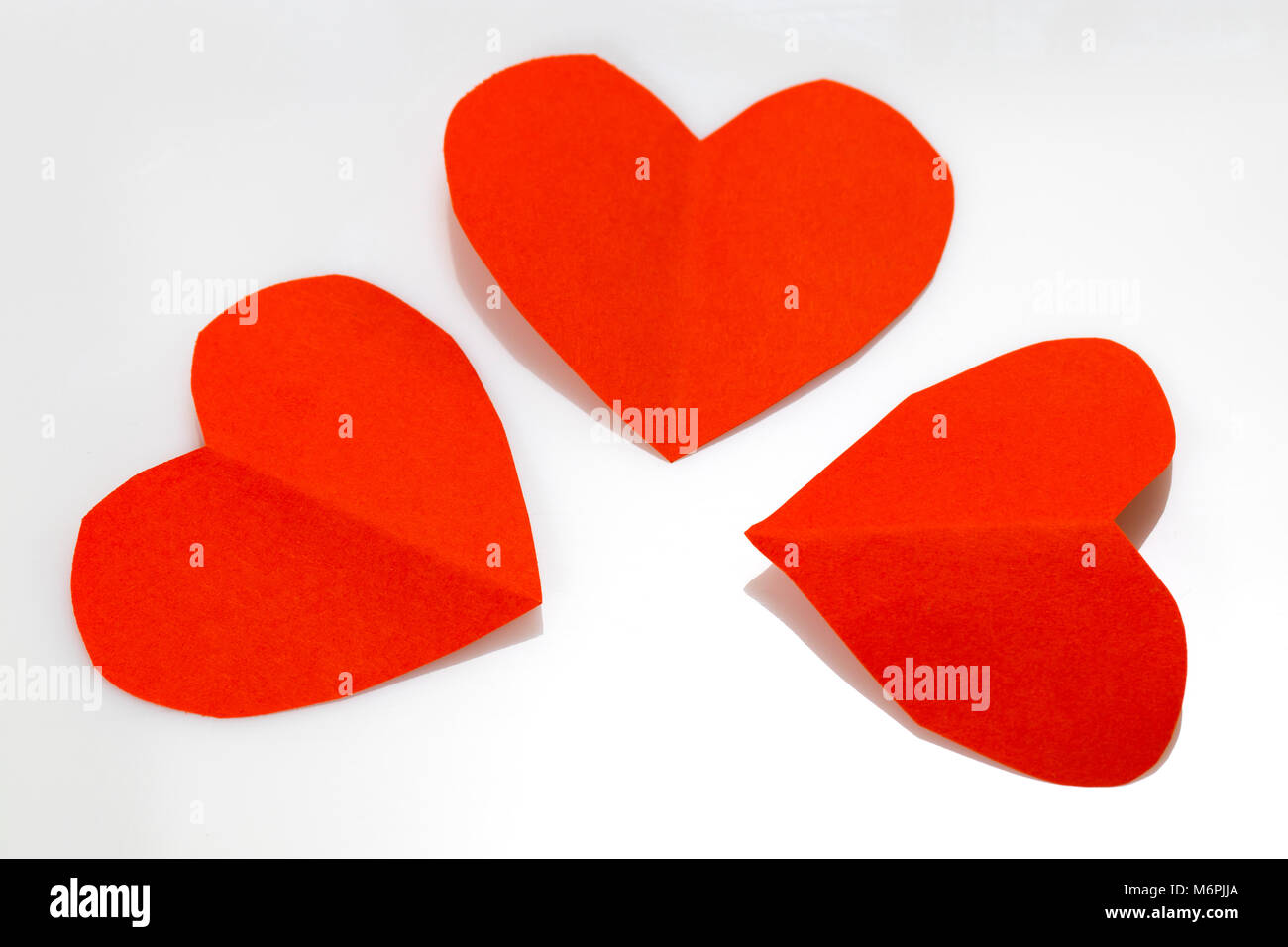 three red hearts isolated on white background Stock Photo - Alamy