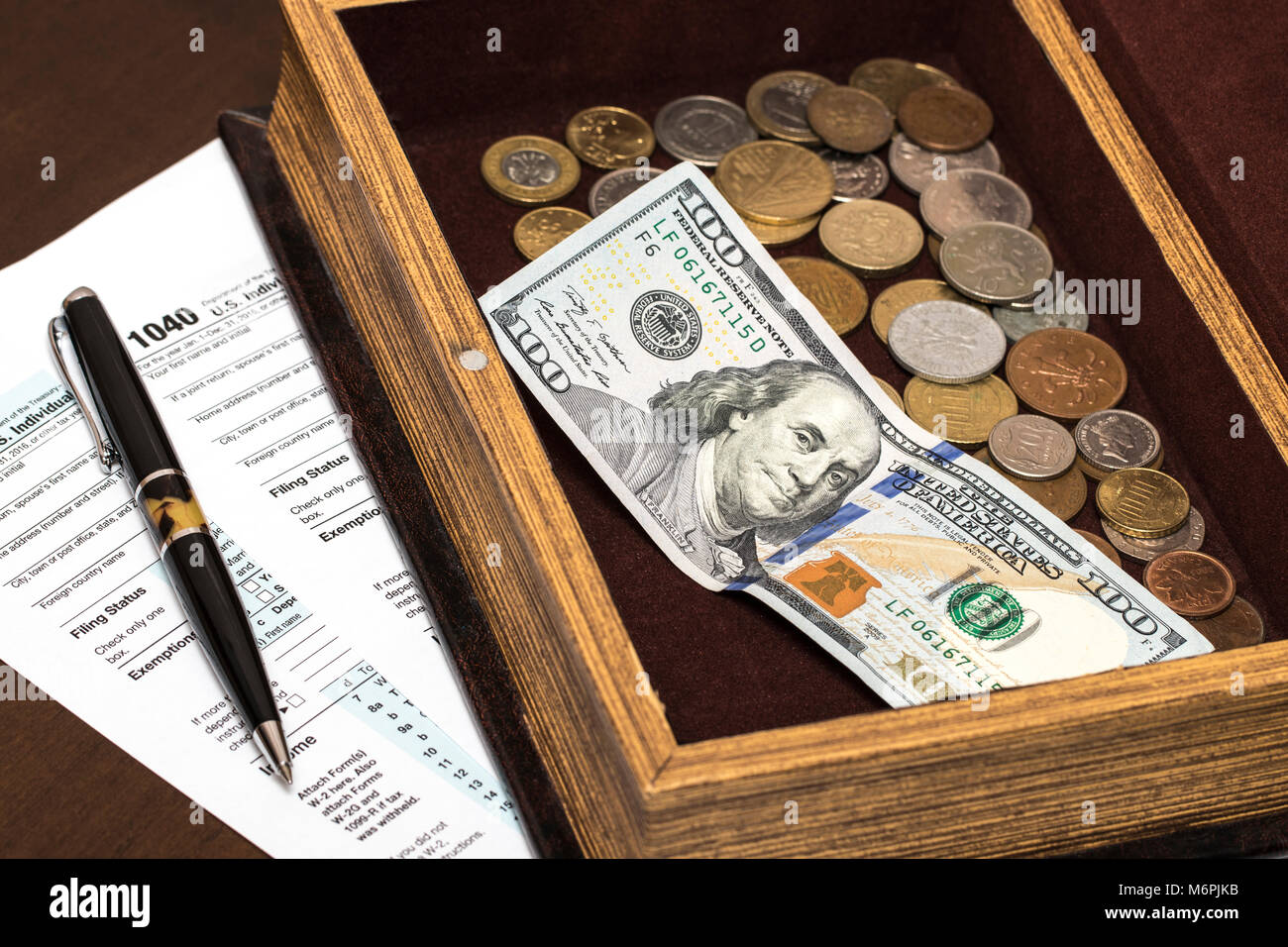 US 1040 tax form with pen, and coins Stock Photo - Alamy