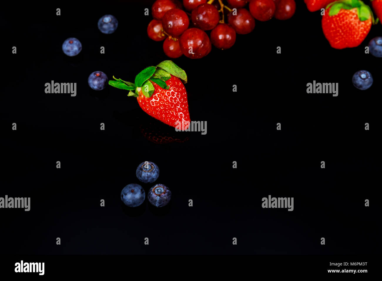 Strawberry, blueberry, plums, grapes on dark background. Fresh fruits ...
