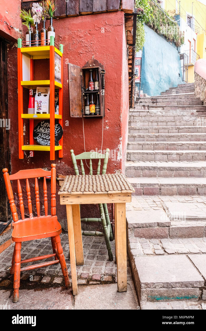 A tiny roadside cafe with one table and two chair by a steep stone ...