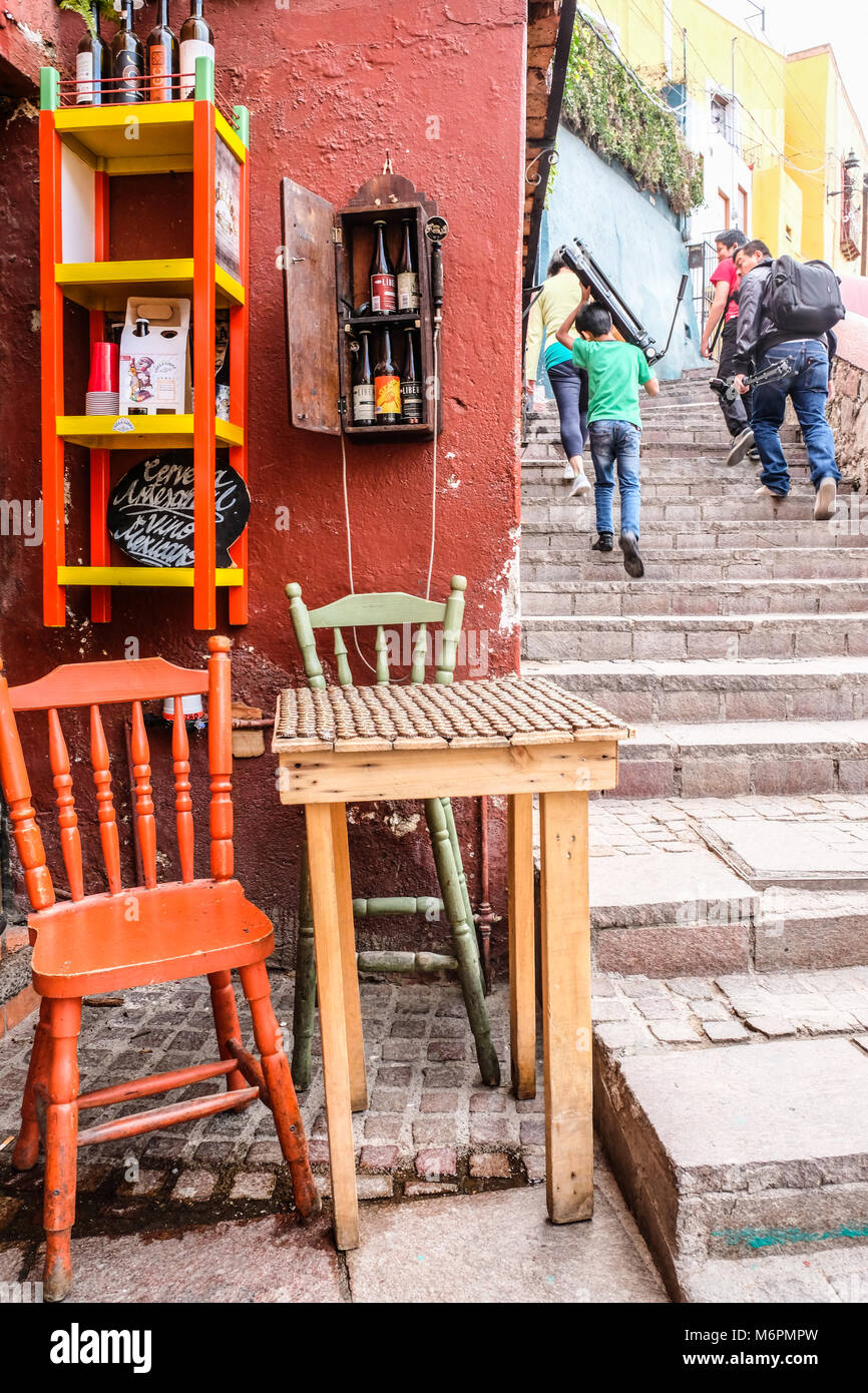 A tiny roadside cafe with one table and two chair by a steep stone ...