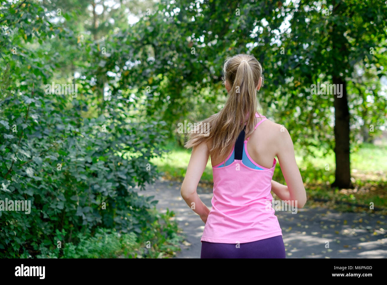 Attractive young woman jogging on park trail. healthy lifestyle concept ...