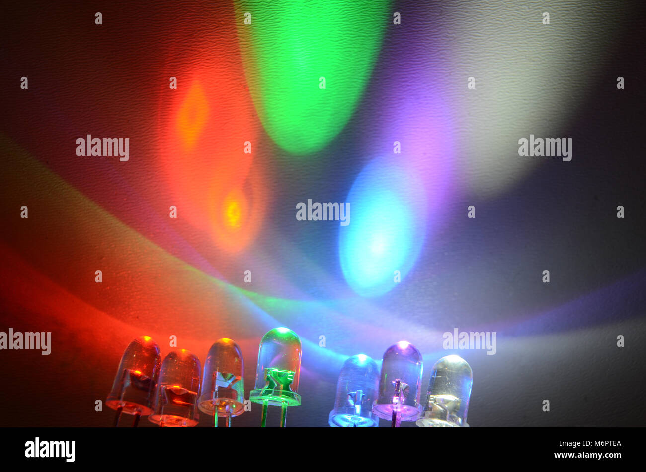 Row of colored LEDs in side view projects light on a white screen Stock ...