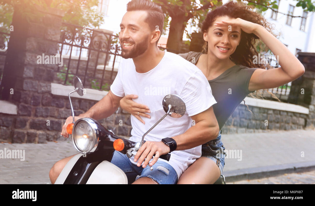 Young couple riding motor scooter in city Stock Photo - Alamy