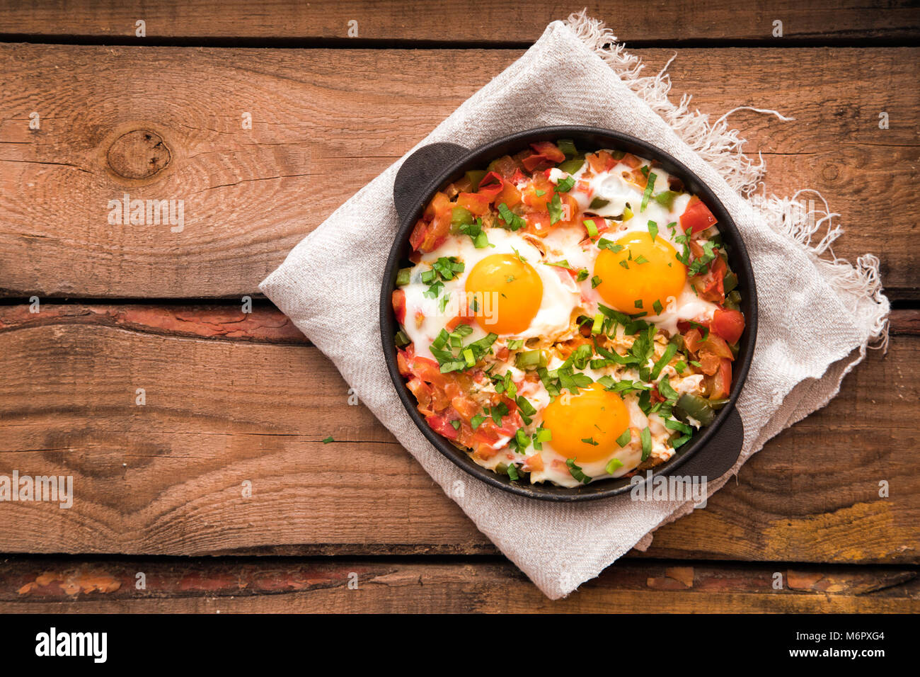 Shakshuka with eggs, tomato, and parsley in a iron pan. Shakshuka ...