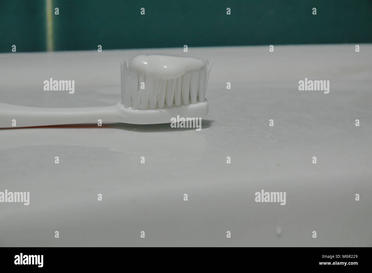 squeeze toothpaste put on toothbrush in bathroom sink Stock Photo - Alamy