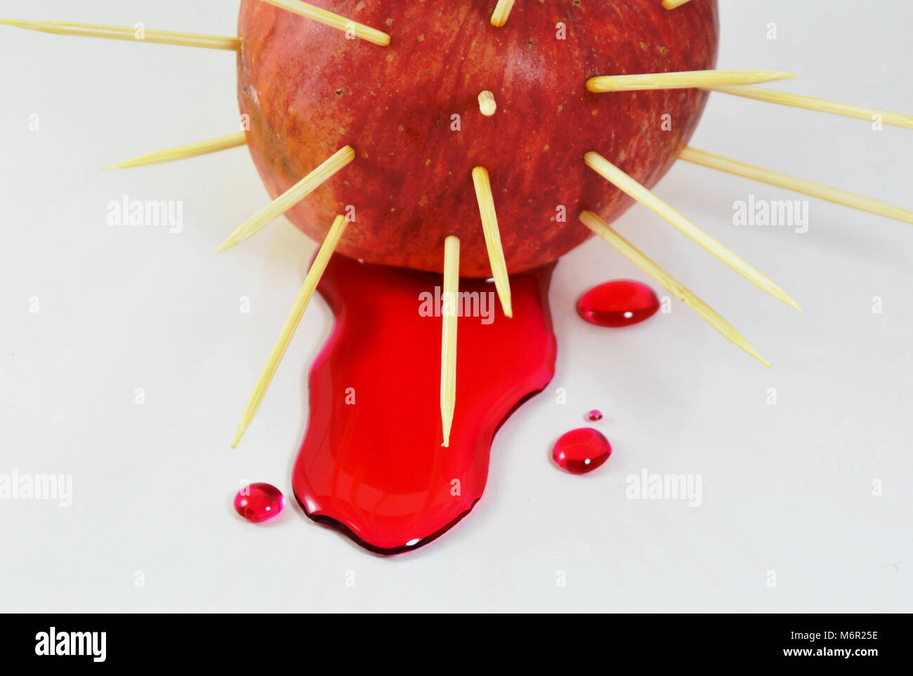 red apple stab by toothpicks and red liquid flow Stock Photo - Alamy