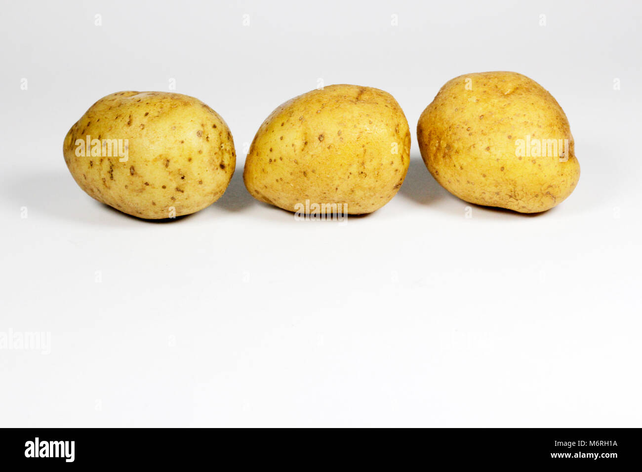 Three potatoes with white background Stock Photo - Alamy