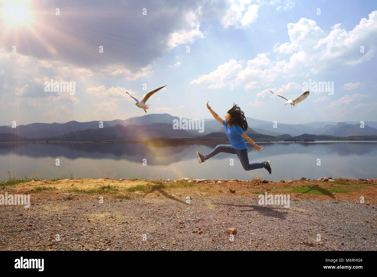 Female feeling happy and jumping at nature view Stock Photo - Alamy