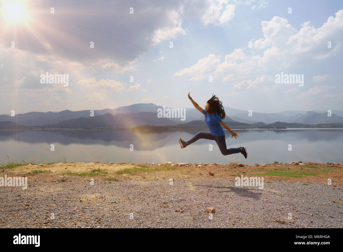 Female feeling happy and jumping at nature view Stock Photo - Alamy