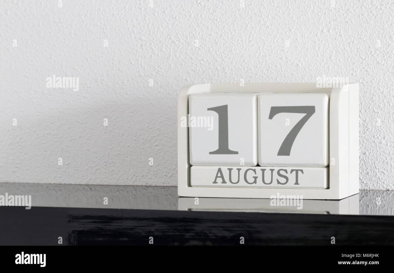 White block calendar present date 17 and month August on white wall ...