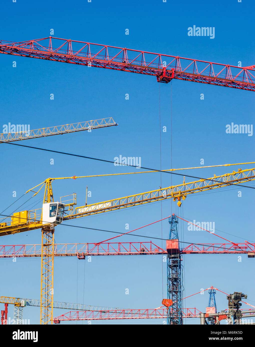 Many construction cranes on blue sky backgrounds. Construction ...