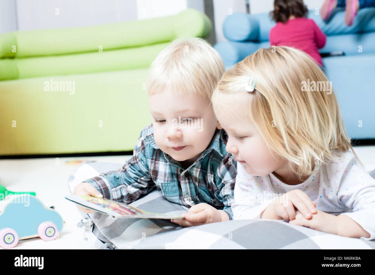 Cute kids review the book Stock Photo - Alamy