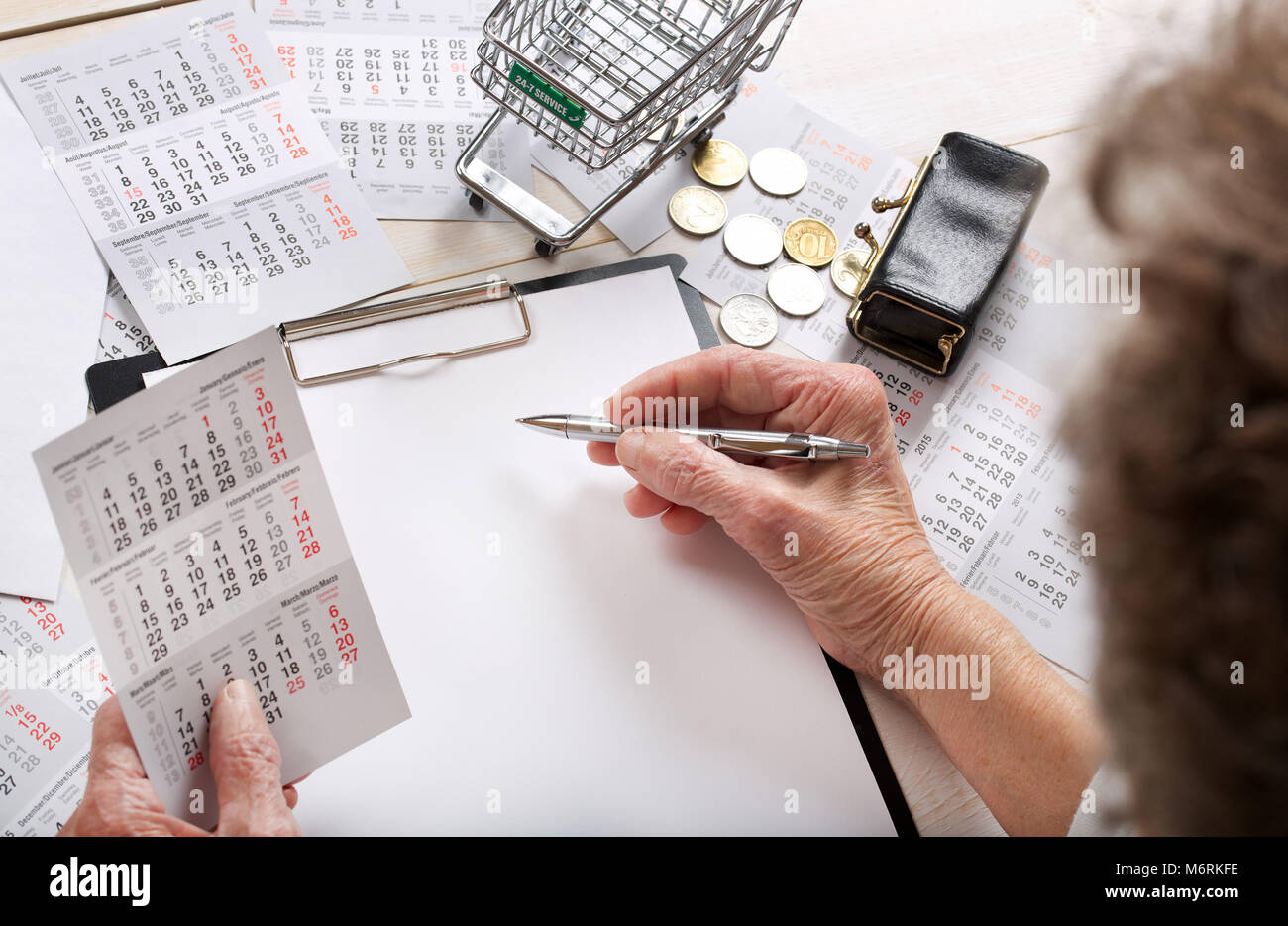 Senior woman between 70 and 80 years old is making some calculation ...