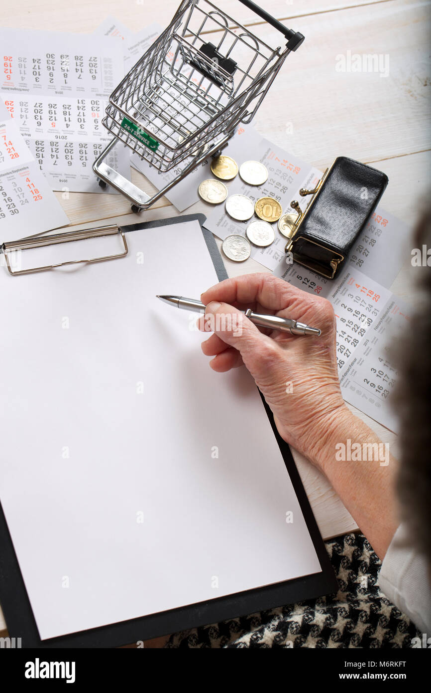 Senior woman between 70 and 80 years old is making some calculation ...