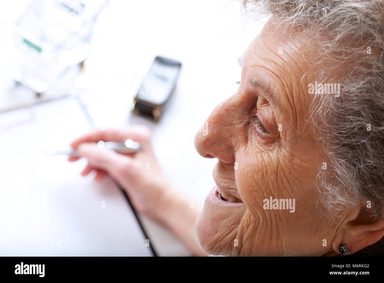 Senior woman between 70 and 80 years old is making some calculation ...