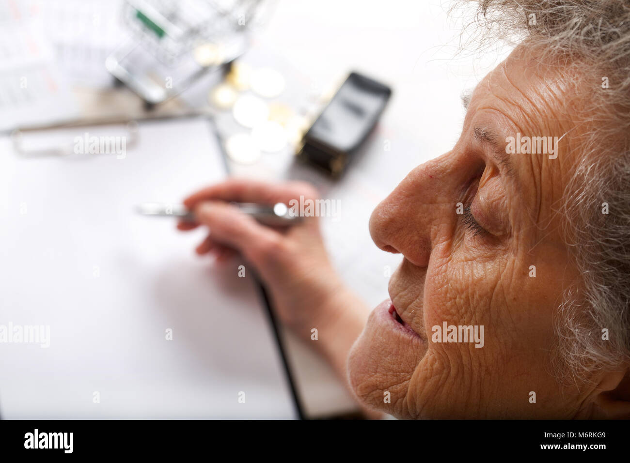 Senior woman between 70 and 80 years old is making some calculation ...