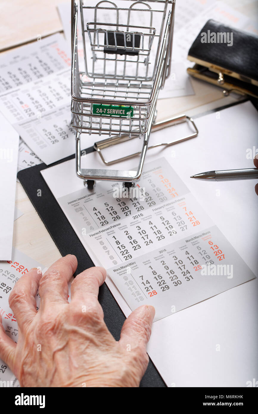 Senior woman between 70 and 80 years old is making some calculation ...