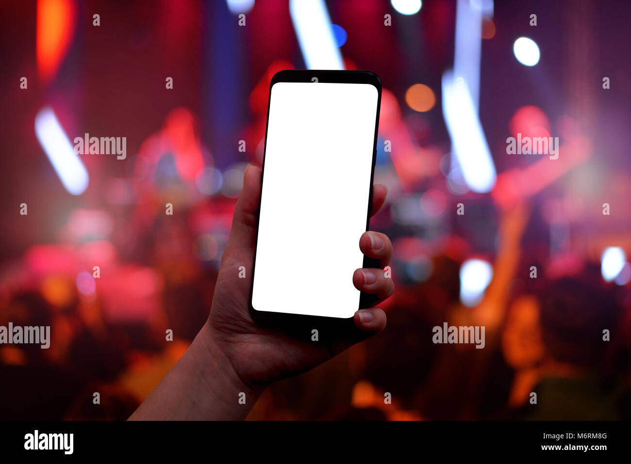 Mobile phone in hand with isolated screen for mockup. Music concert red ...