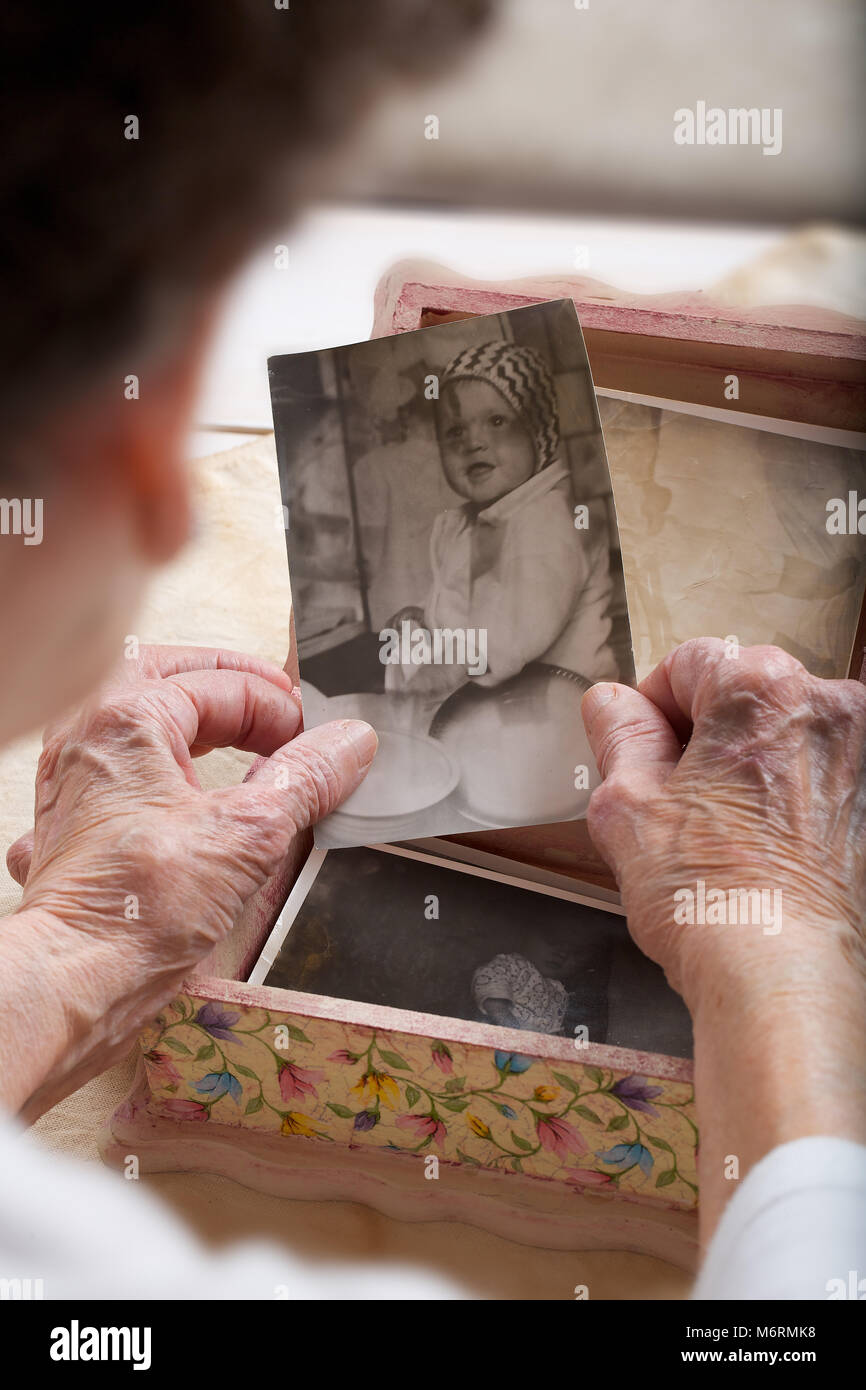 Old woman opens a wooden made box with her photos Stock Photo - Alamy