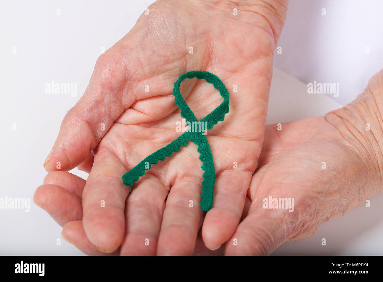 Senior woman keeps a green felt ribbon.Closeup Stock Photo - Alamy