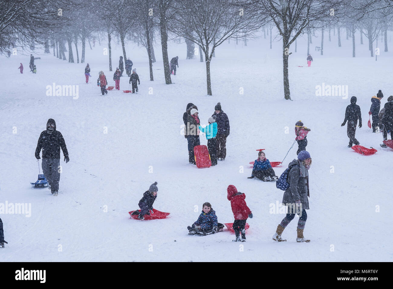 People sledging and enjoying the snow in Glasgow's Victoria park Stock ...